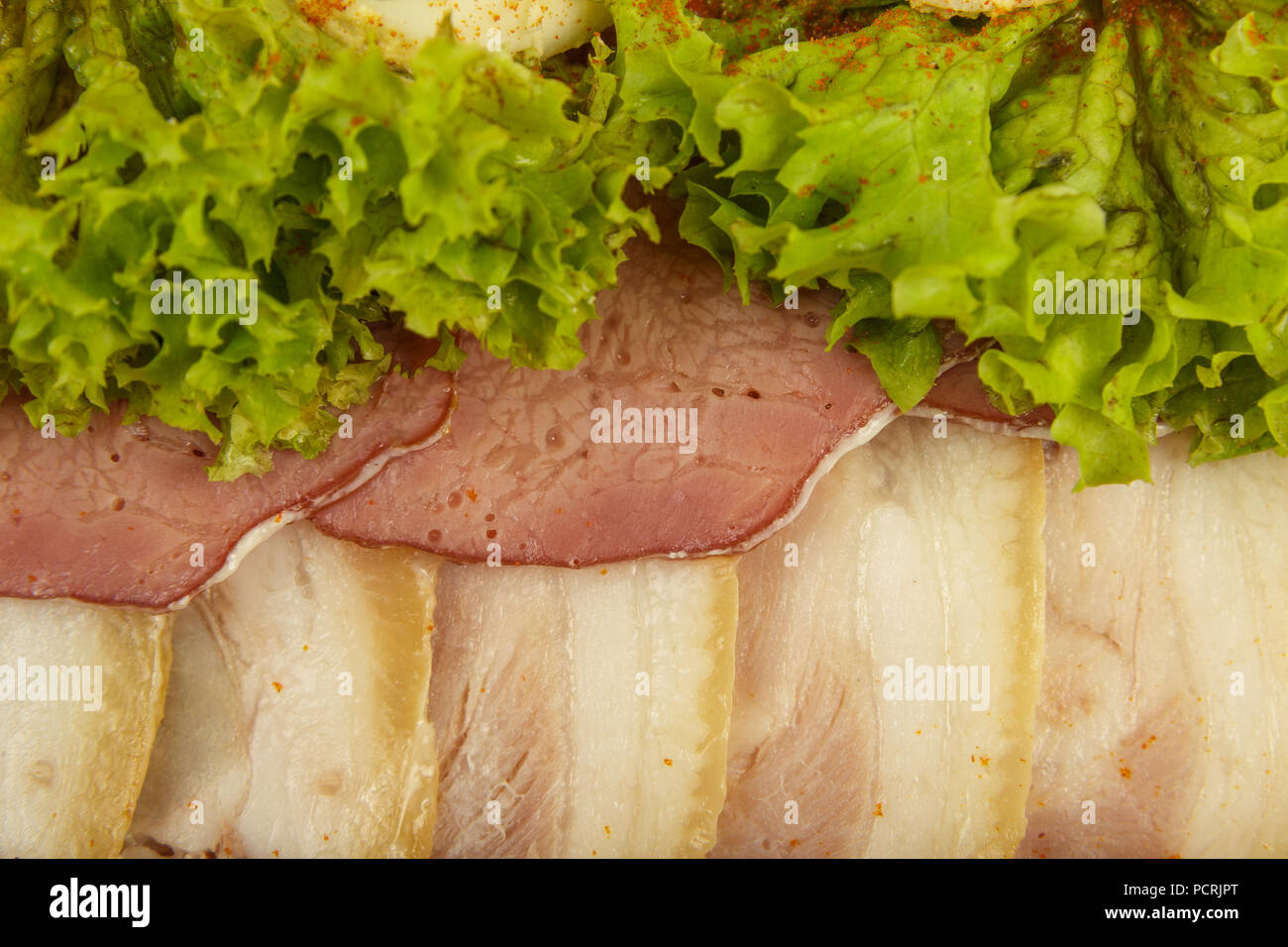Meat sliced on a mirror dish decorated with verdure Stock Photo - Alamy