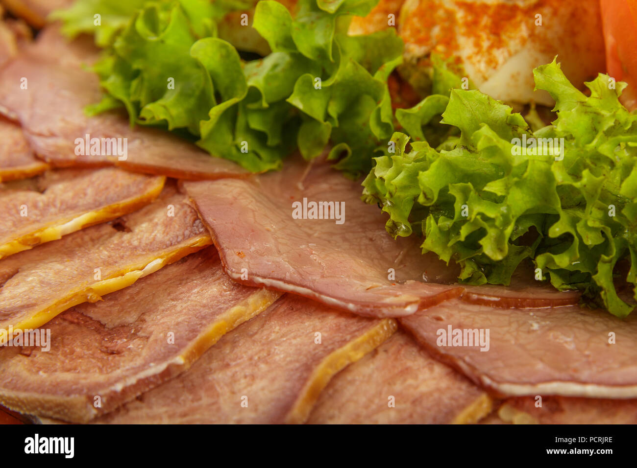 Meat sliced on a mirror dish decorated with verdure Stock Photo - Alamy