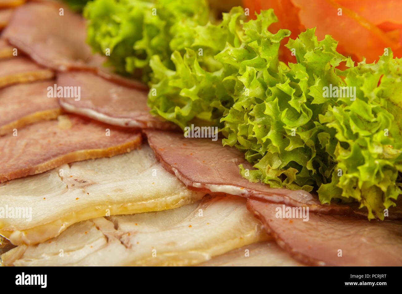 Meat sliced on a mirror dish decorated with verdure Stock Photo - Alamy