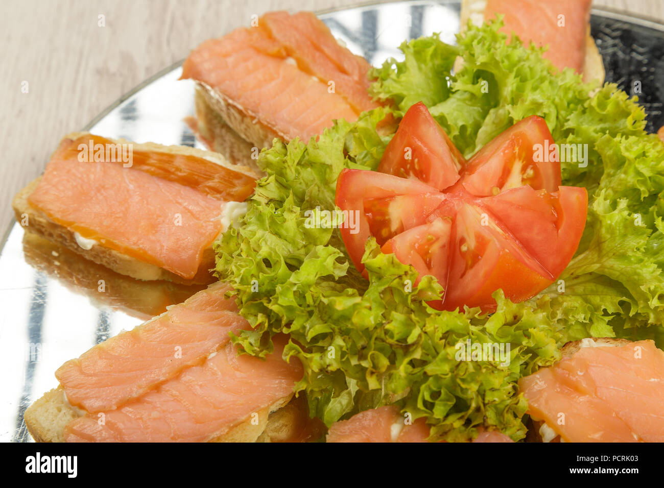 Dish of sandwiches with red fish tomato and greens Stock Photo - Alamy