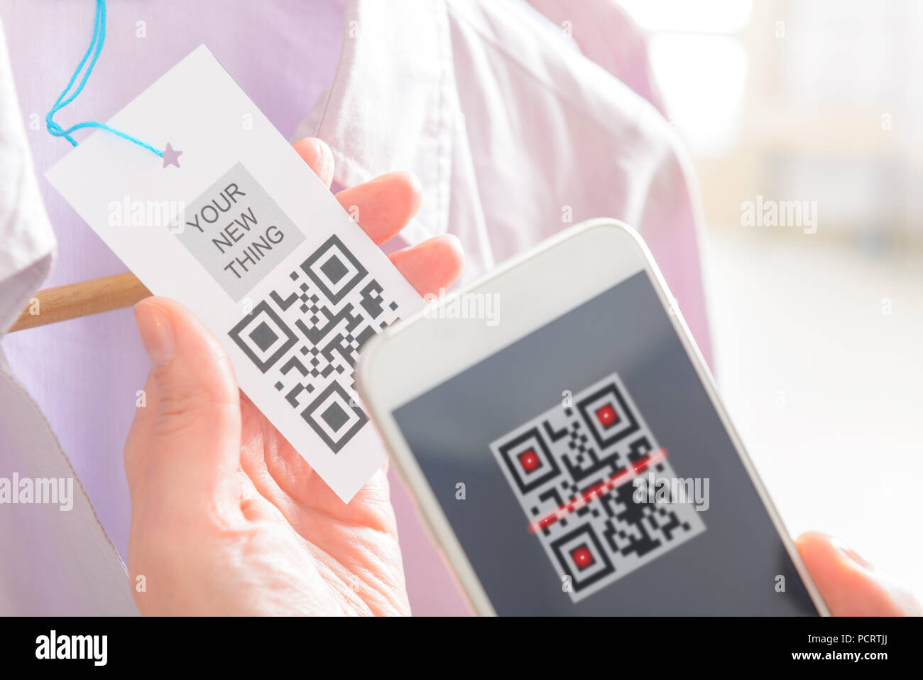 Woman scanning QR code from a label in a shop with mobile phone Stock ...