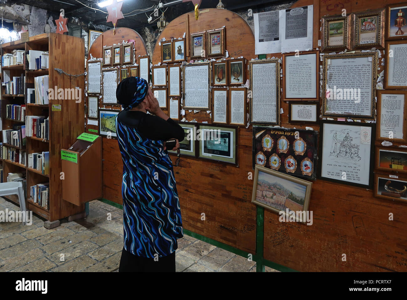 Religious Jewish woman reading prayer notes inside the cave associated ...