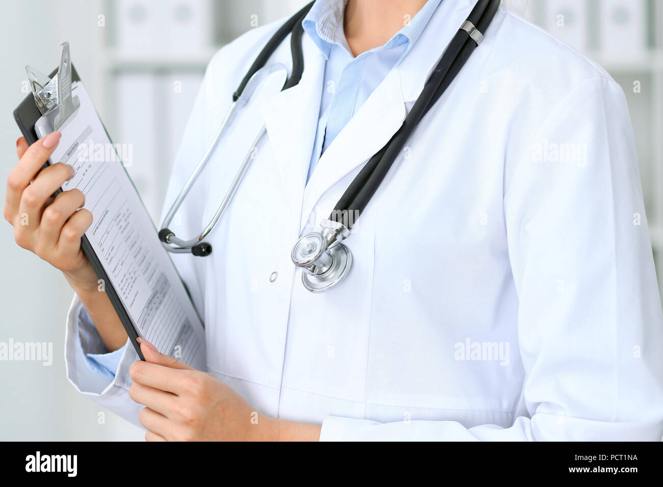 Closeup of unknown doctor woman standing with medication history ...