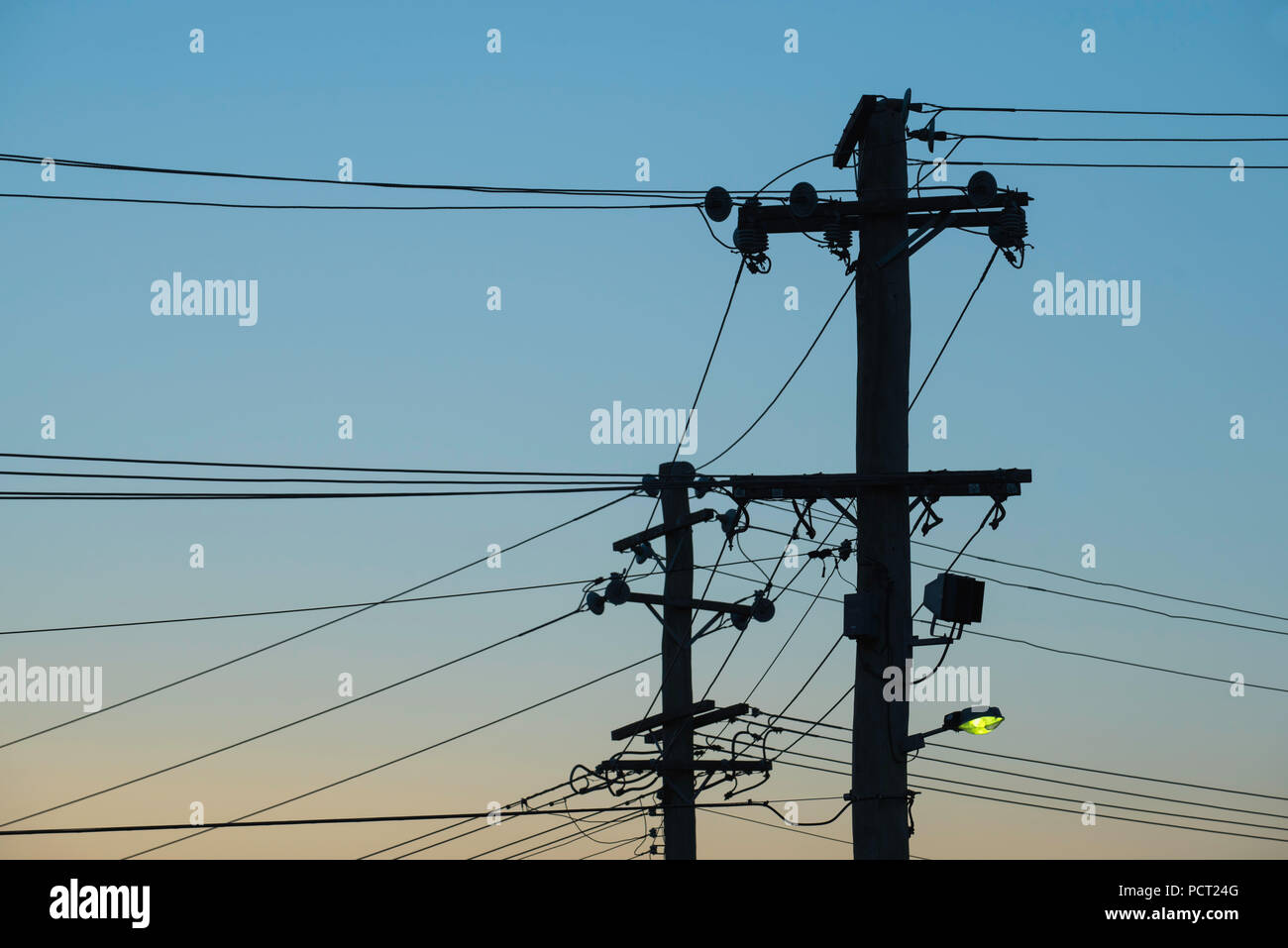 Two Australian timber electricity power poles with street lights turned ...