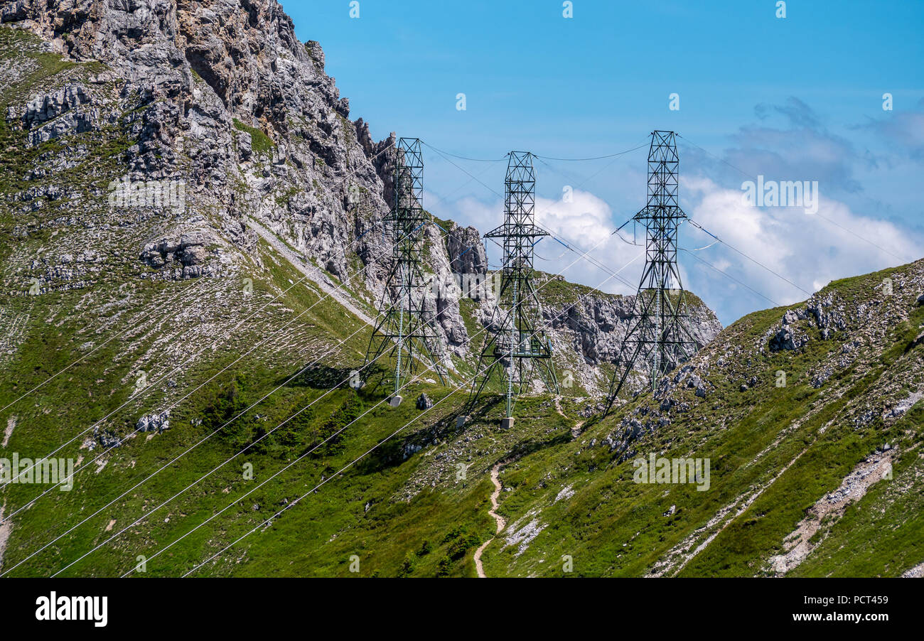 three high voltage post power poles high up in the mountains high ...