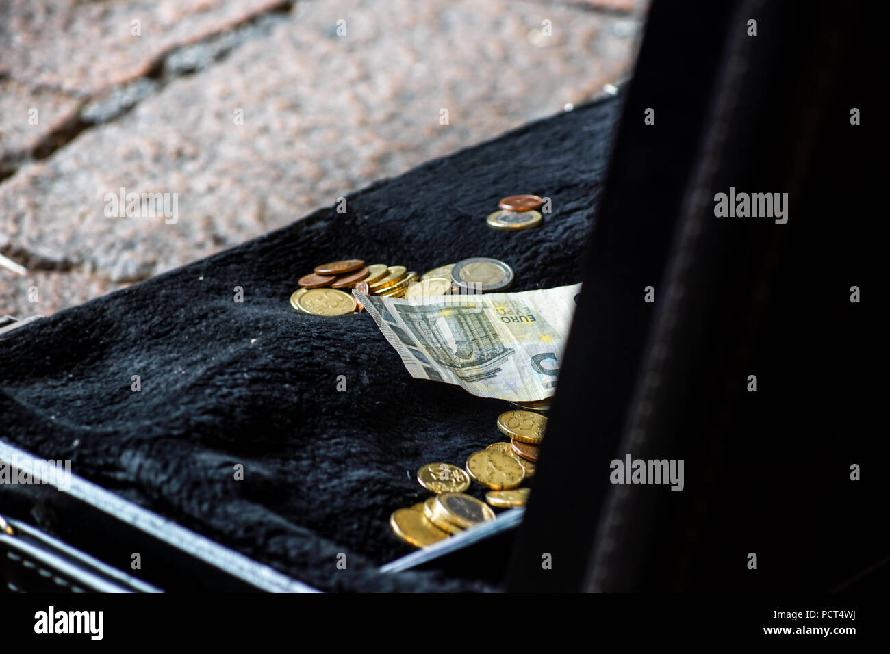 Hand throwing money in the old hat from a street artist, finance ...