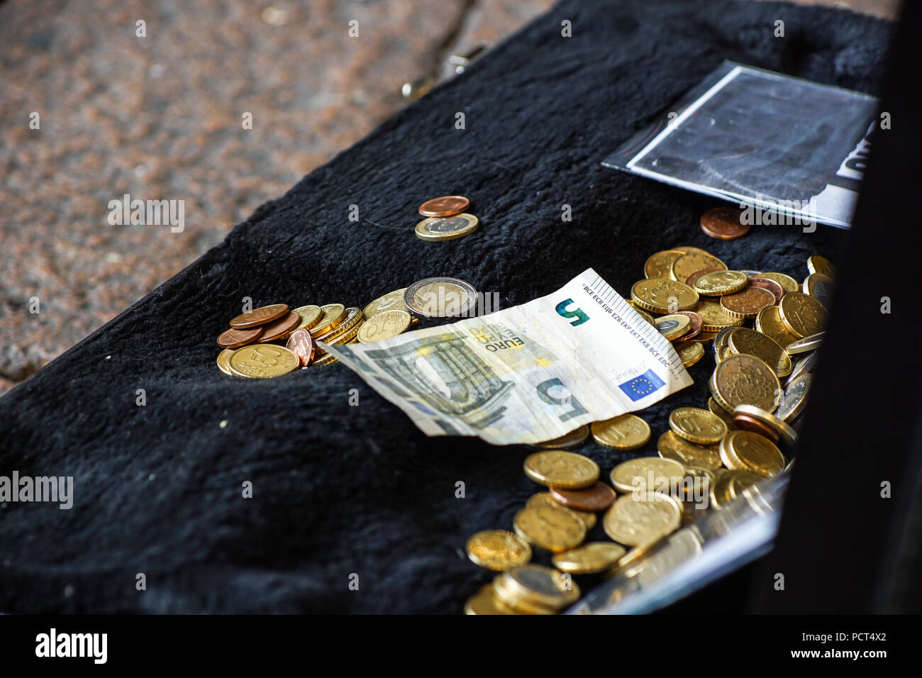 Hand throwing money in the old hat from a street artist, finance ...
