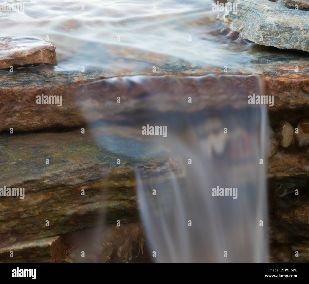 Small waterfall with rocks and water flowing over it Stock Photo - Alamy