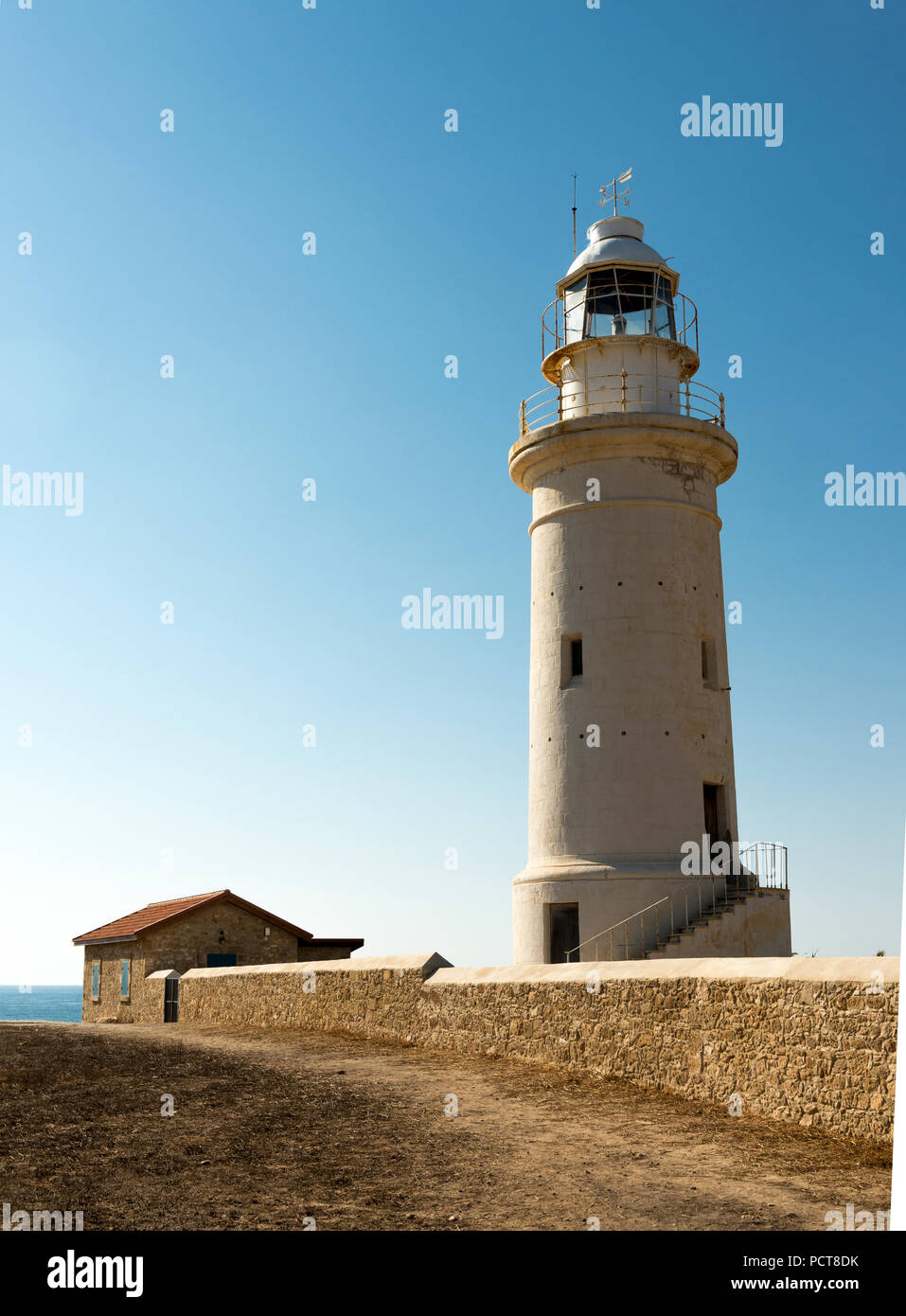 A lighthouse behind a limestone wall in Paphos Archaeologial Park ...