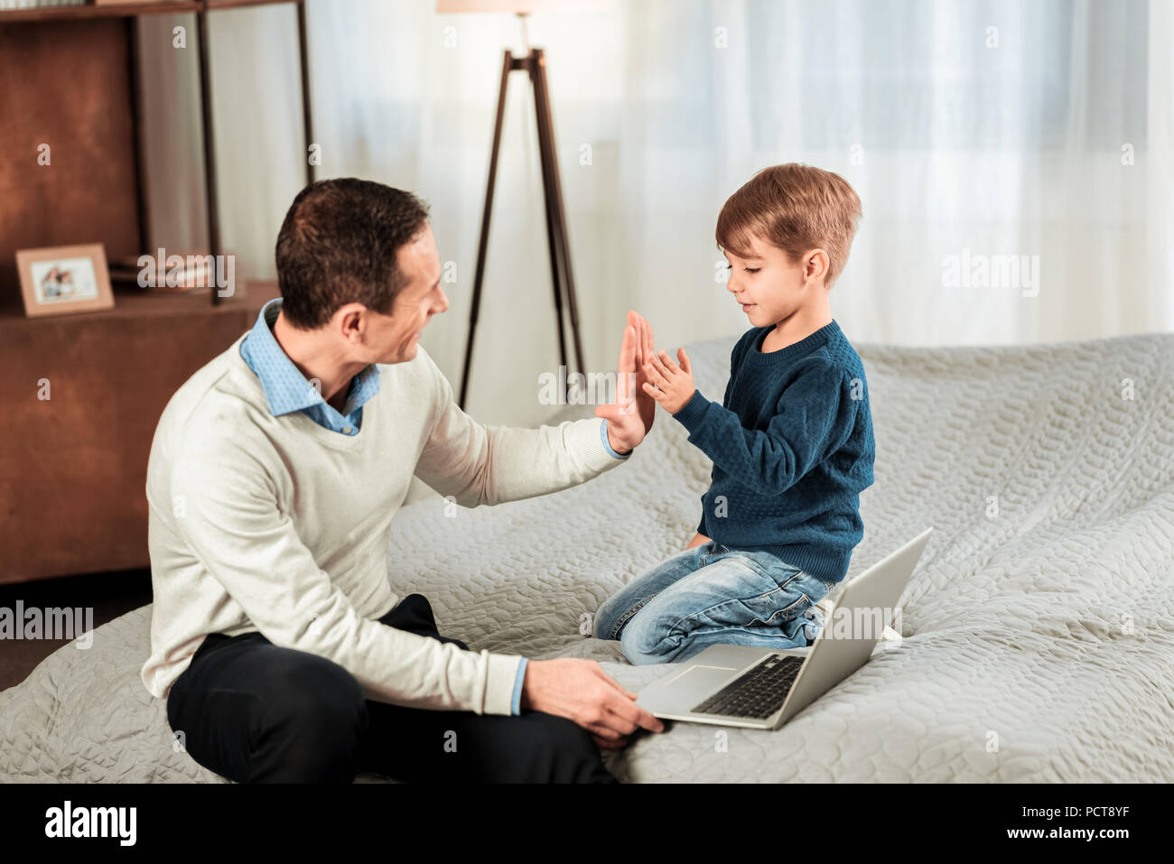 Joyful nice man giving high five Stock Photo - Alamy