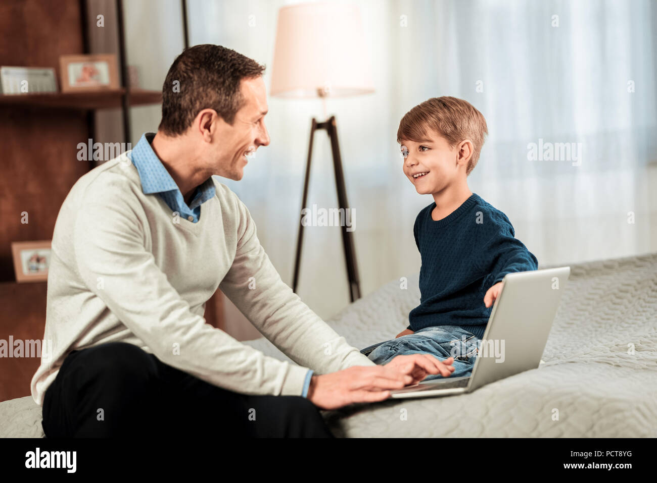 Happy positive father and son smiling to each other Stock Photo - Alamy