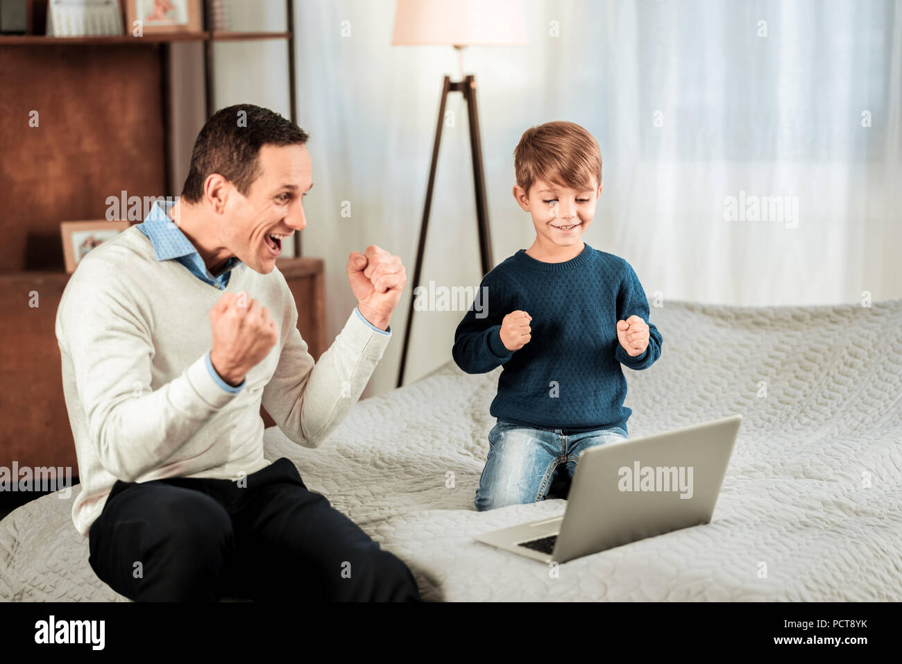 Nice positive father and son feeling happy Stock Photo - Alamy