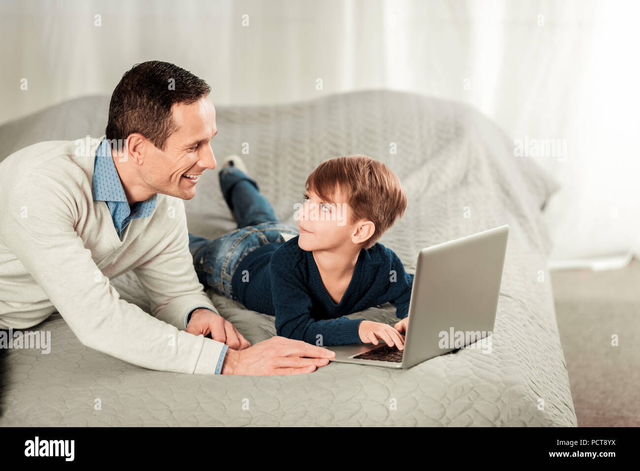 Nice pleasant boy looking at his father Stock Photo - Alamy