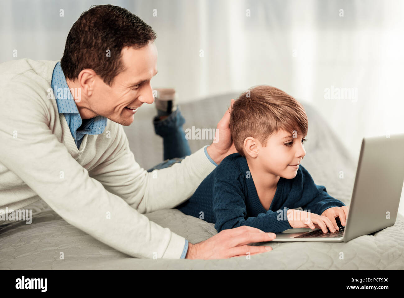 Pleasant cute boy typing Stock Photo - Alamy