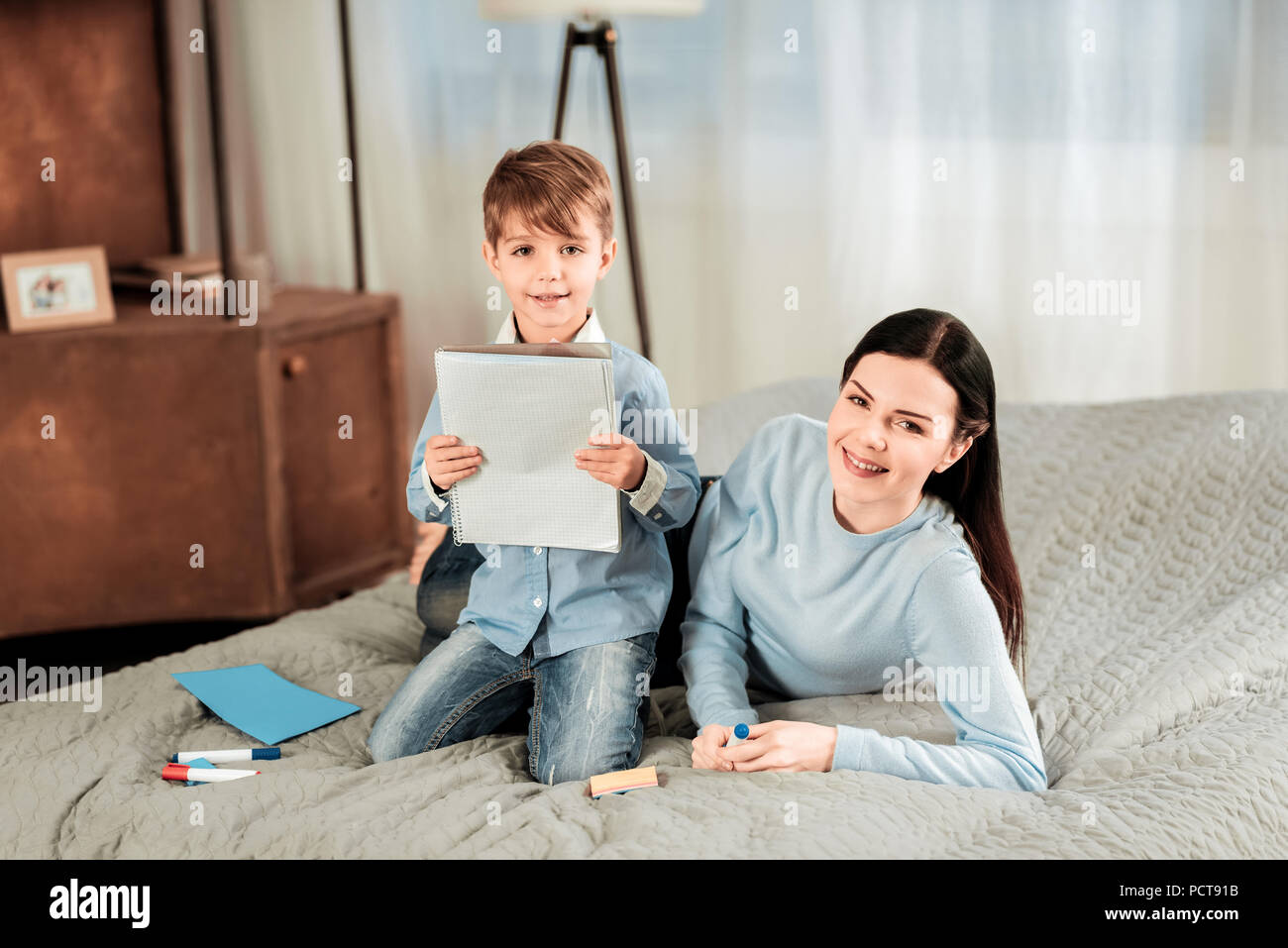 Positive cute boy holding his notebook Stock Photo - Alamy