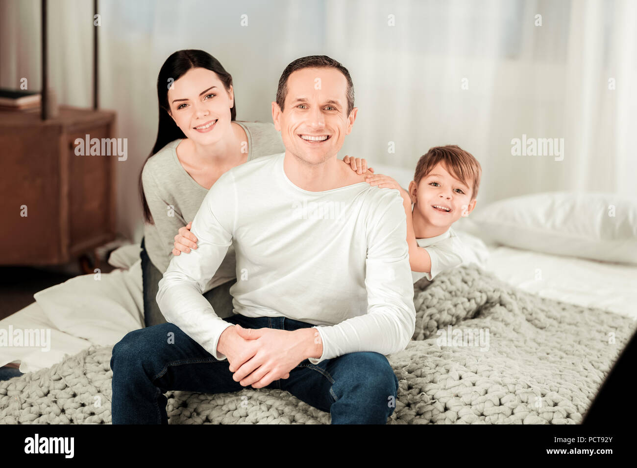 Joyful delighted family sitting together Stock Photo - Alamy