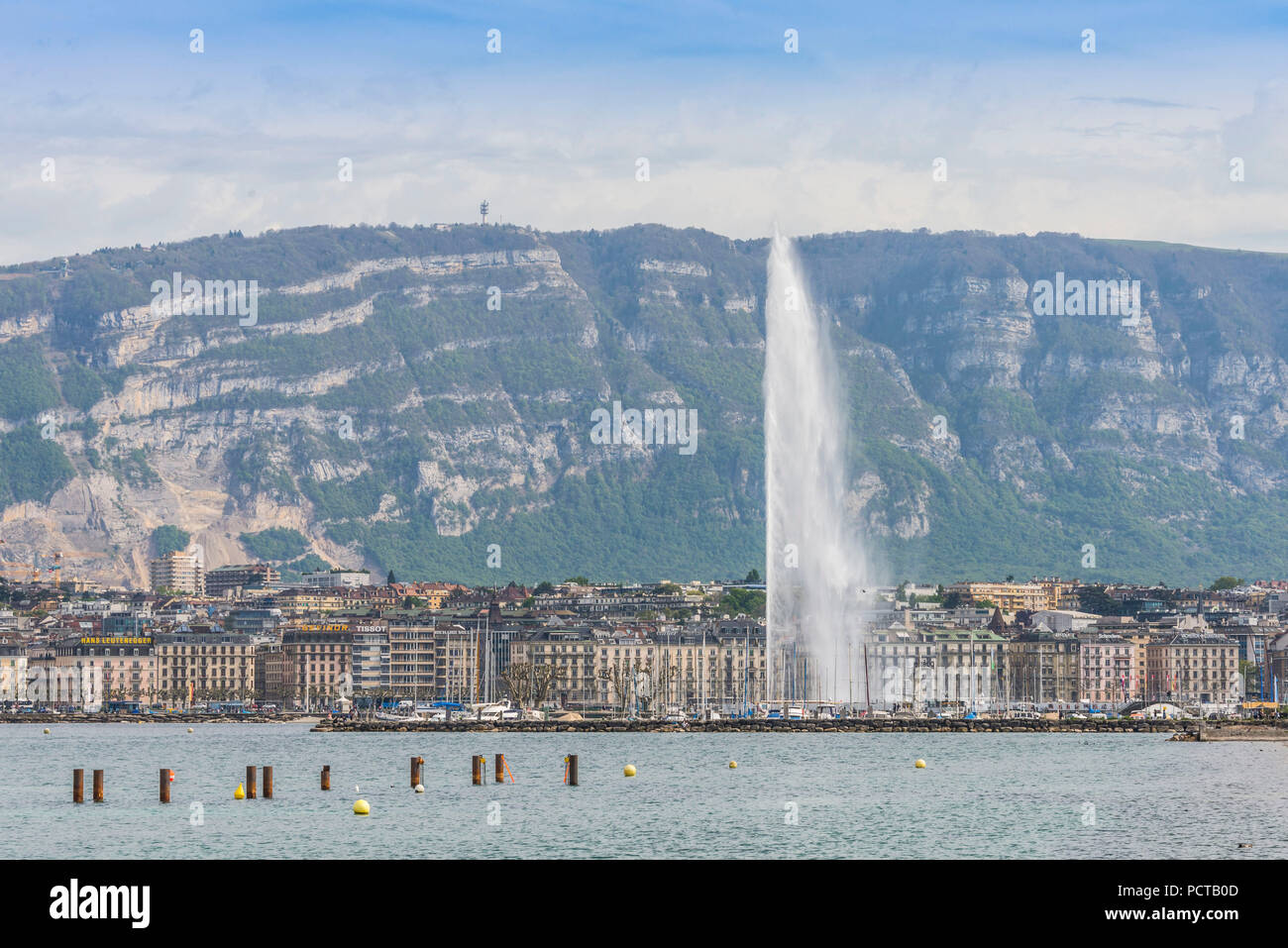 View of lake with fountain Jet d'eau in front of waterfront, Geneva ...