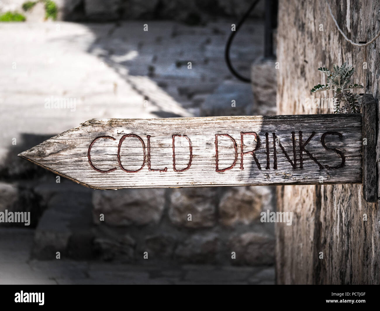 Close up photograph of a weathered gray and brown wood cold drinks sign ...