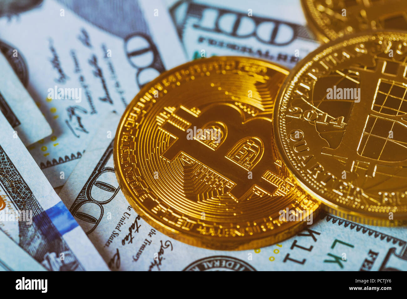 Close-up. Gold Bitcoin on hundred dollars bills. Bitcoin on us dollar ...