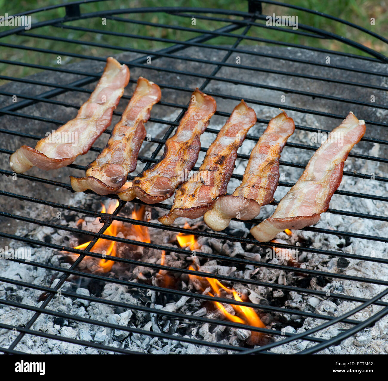 Bacon slices grilling on a Fire Stock Photo - Alamy