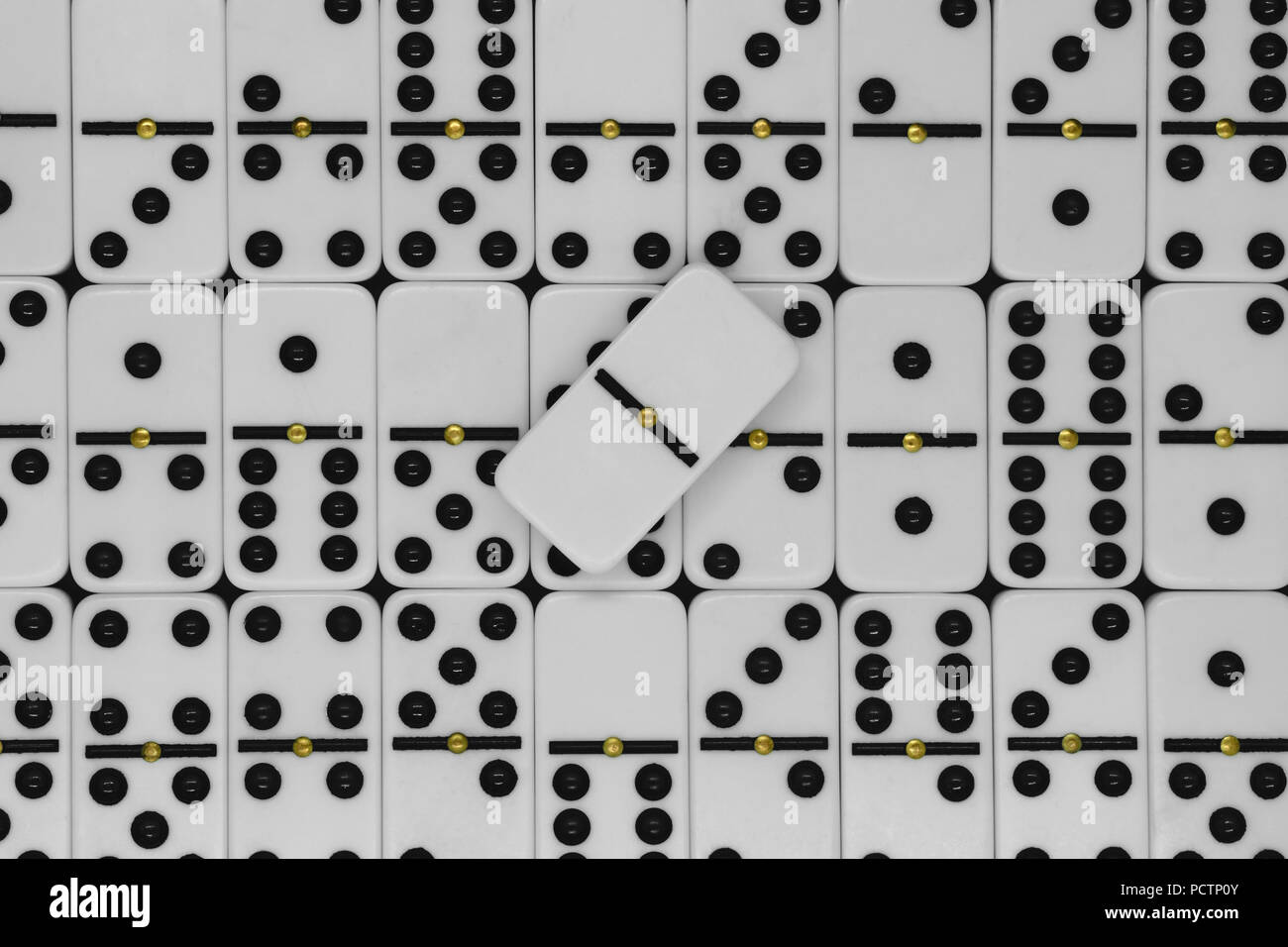 White plastic dominoes with black dots background surface and one blank ...