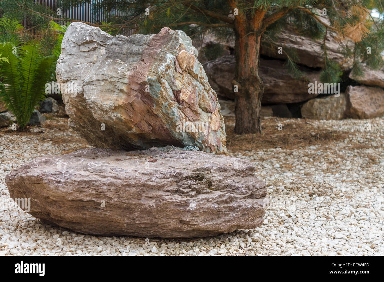 A group of decorative stones on pebbles as a yard decoration in ...