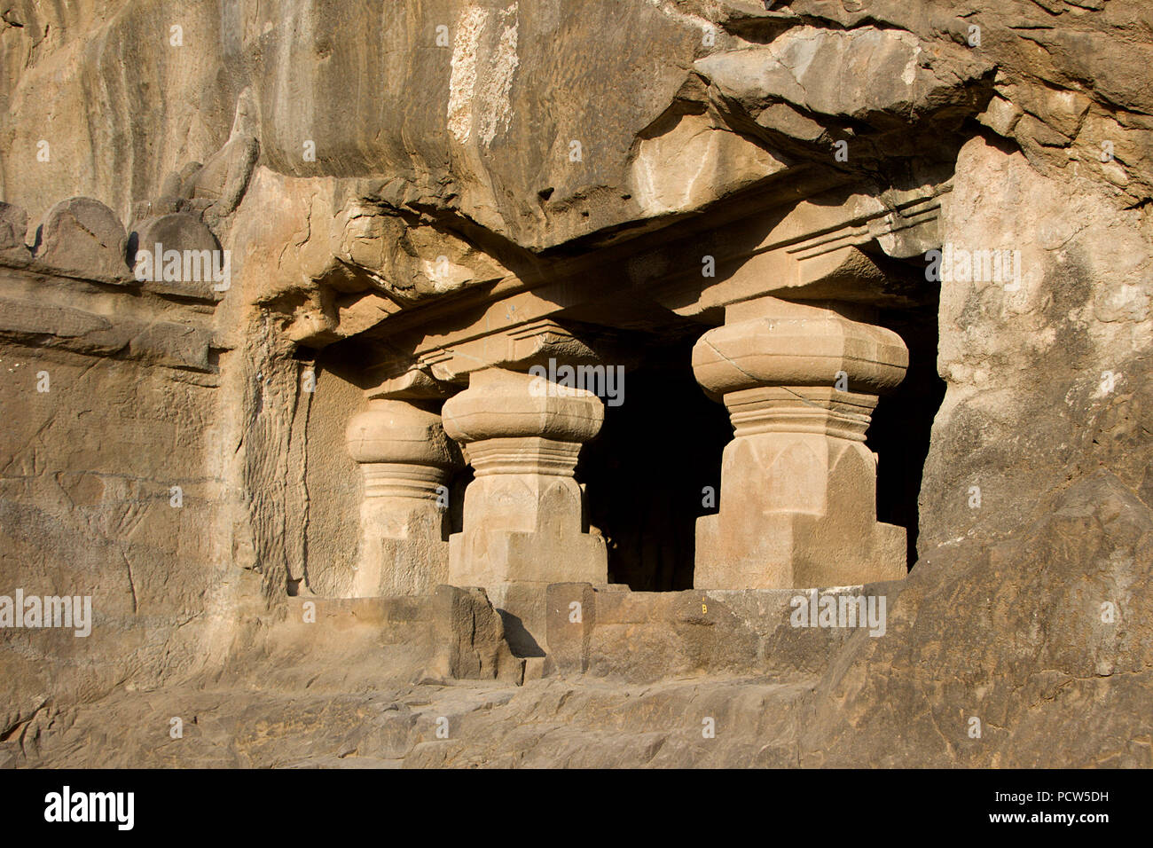 Frontal view of huge pillars at entrance of cave temple at Ellora ...