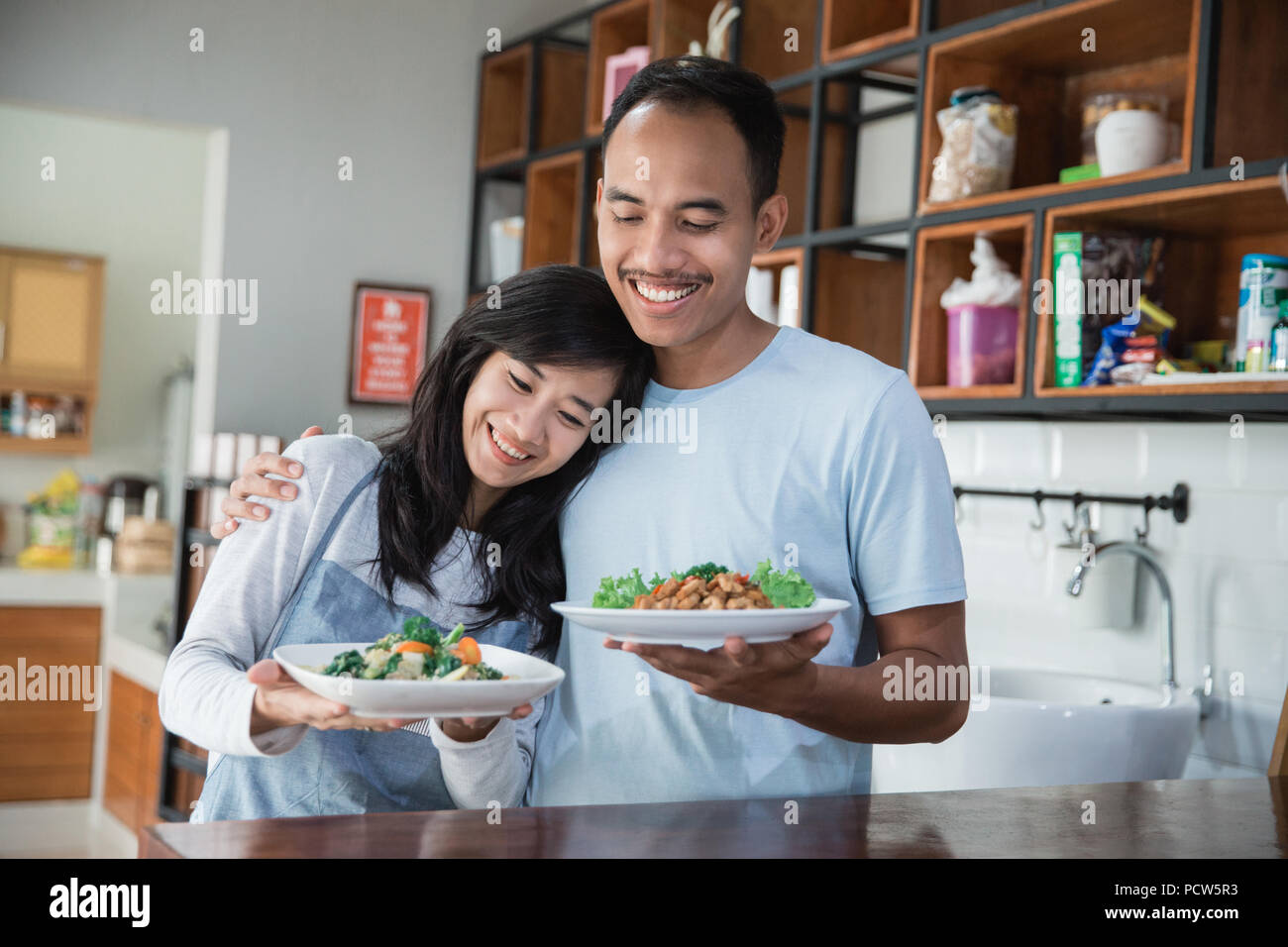 beautiful asian wife in the kitchen with husband preparing food for ...