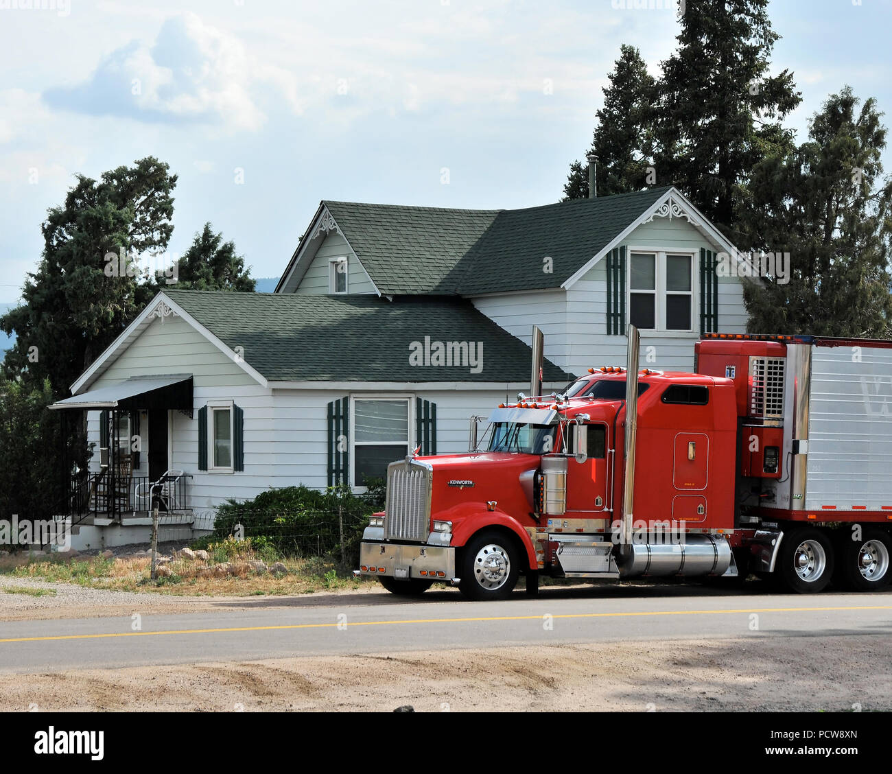 A semi truck beside a cottage in a small town after the run.Editorial ...