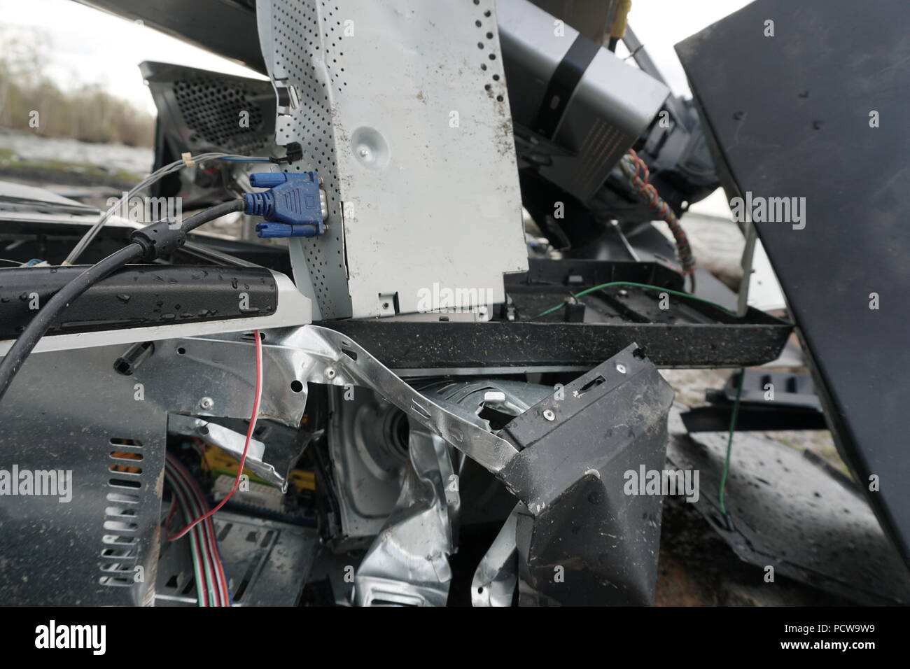 Broken computer parts, monitors and printers in front of nature ...
