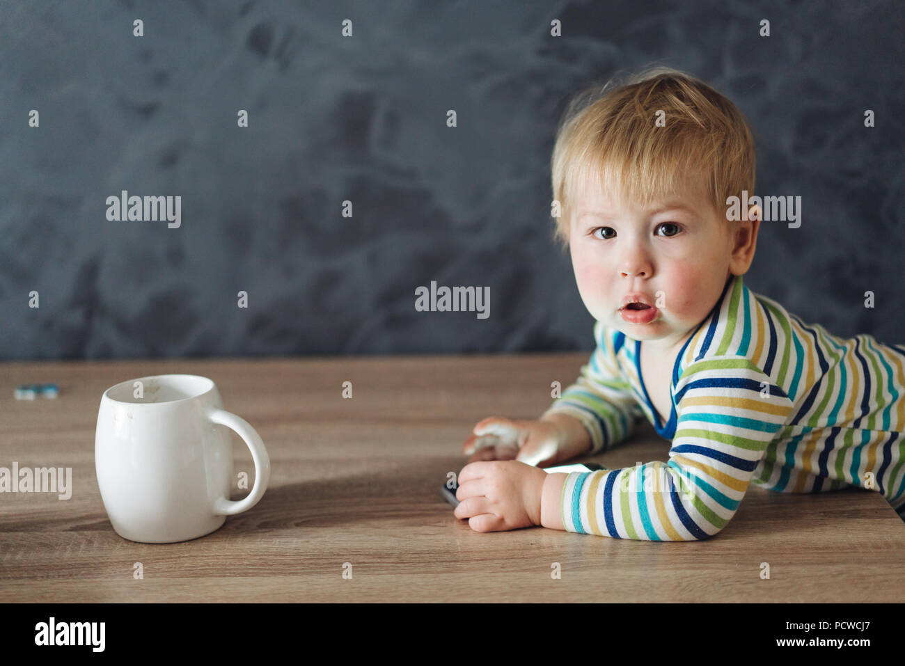 baby boy standing near the table Stock Photo - Alamy