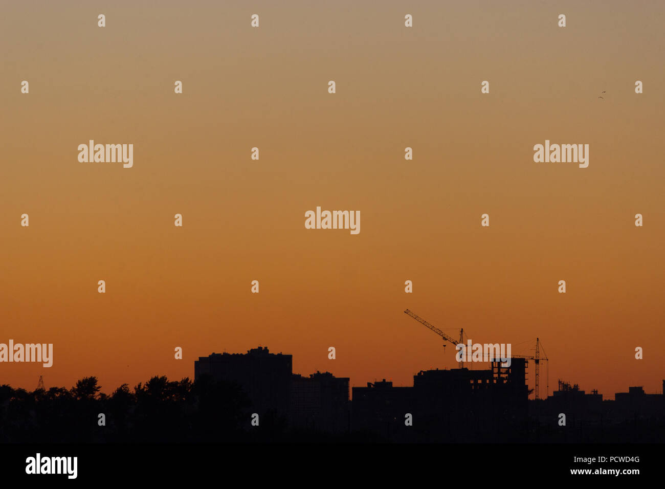tower cranes at construction site. sunset sky Stock Photo - Alamy