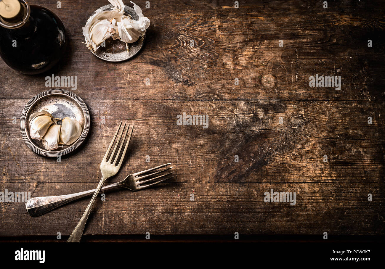 Dark rustic aged wooden food background with cutlery and seasoning, top ...