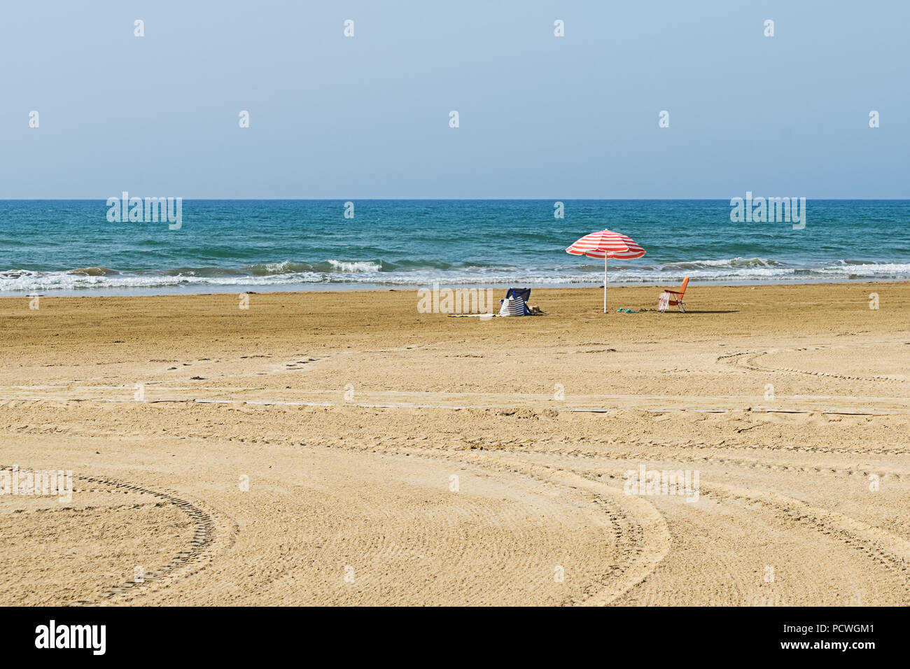 Empty sandy beach with one parasol on coastline, minimal copy space ...