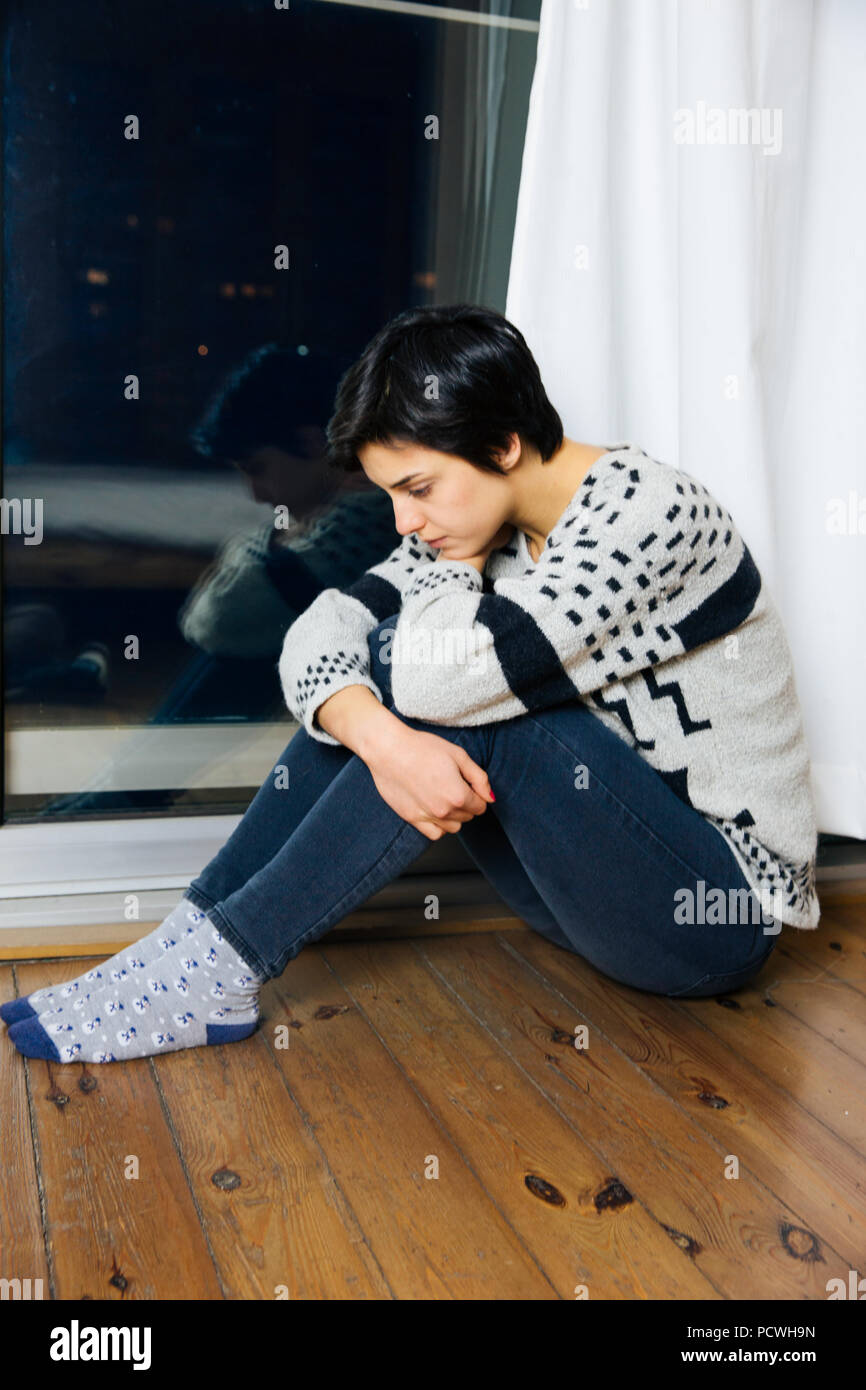 Sad woman sitting on the floor in corner of room, portrait of a sad ...