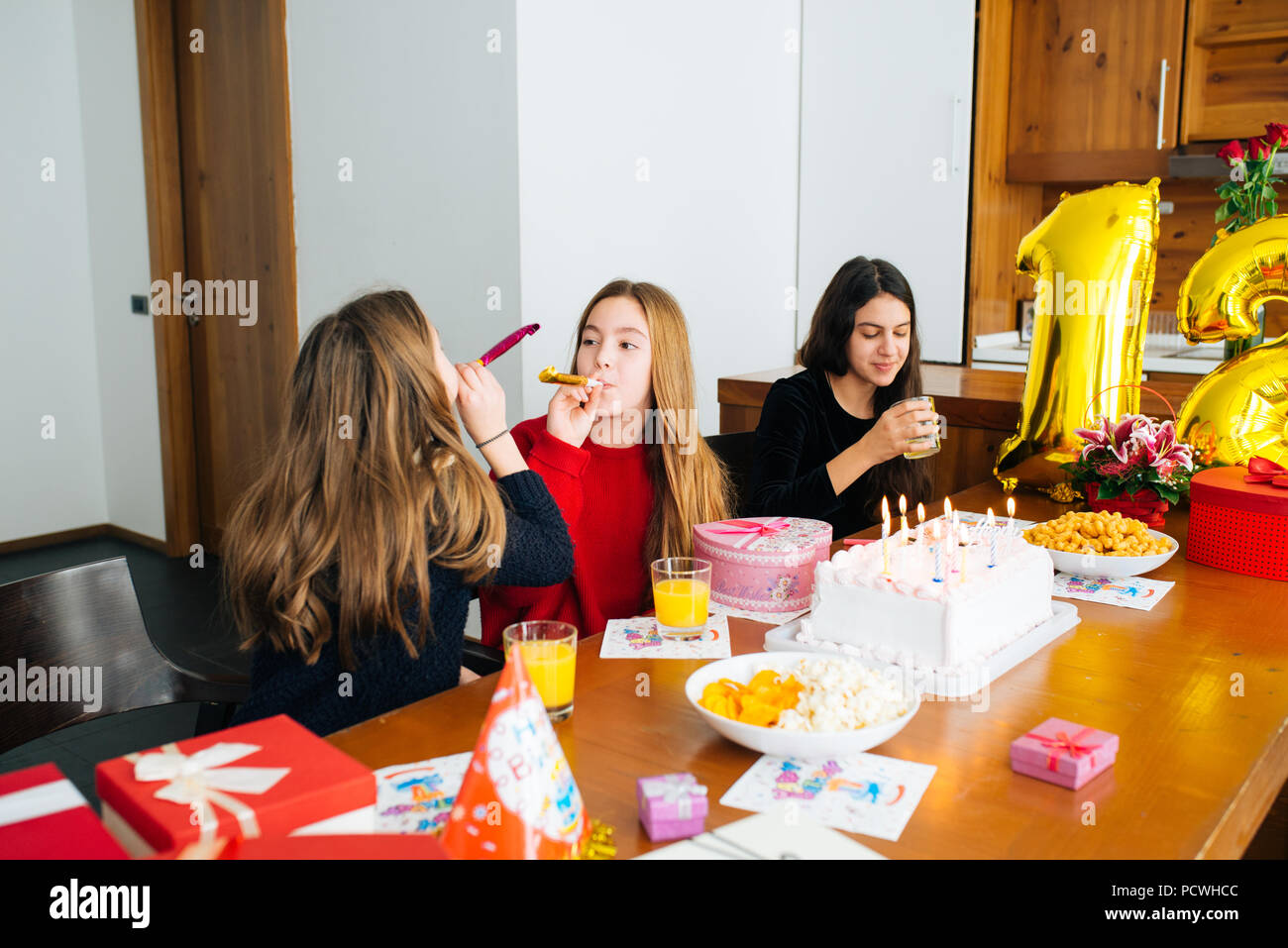Group of kids celebrate birthday together and blowing in the whistles ...