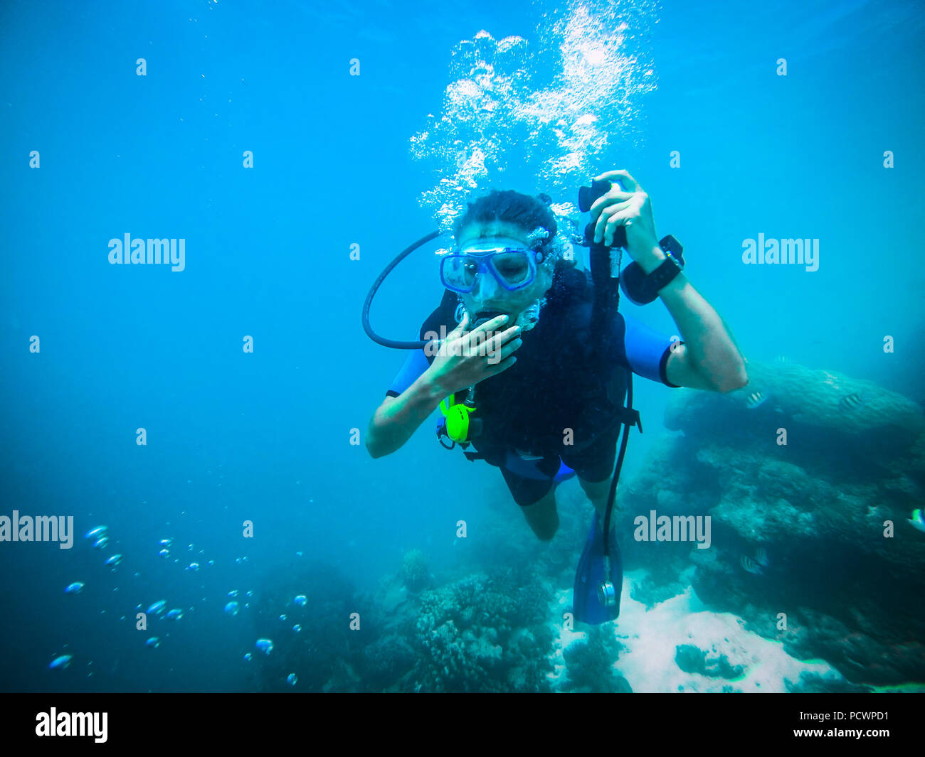 Female scuba diver equalizing the pressure on Oliveli island , Maldives ...