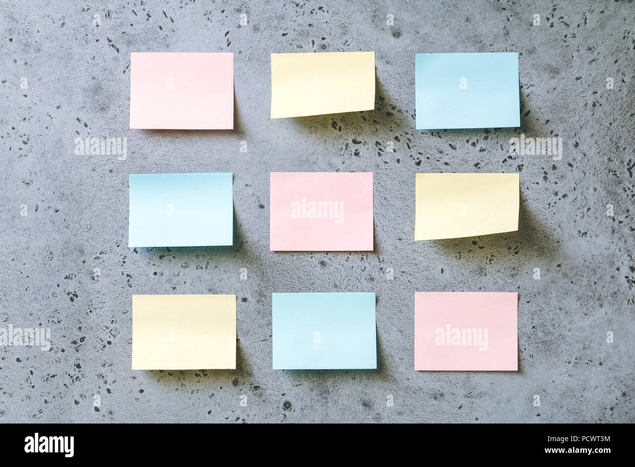 Colorful empty sticky notes on a grey textured background. The concept ...
