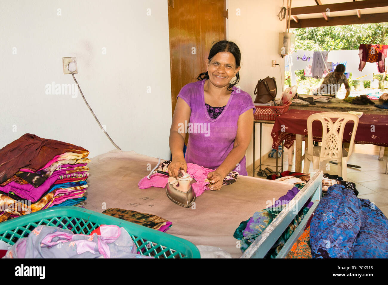 WELIGAMA, SRI LANKA - JAN 7, 2017: Asian woman ironing clothes ...