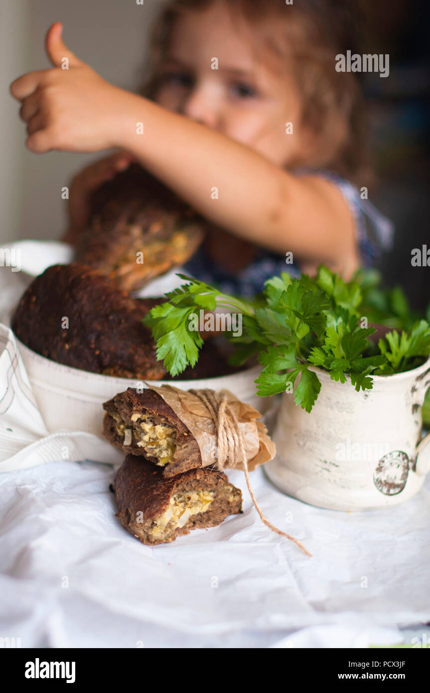 A little girl is eating pies in the living room. Delicious homemade ...