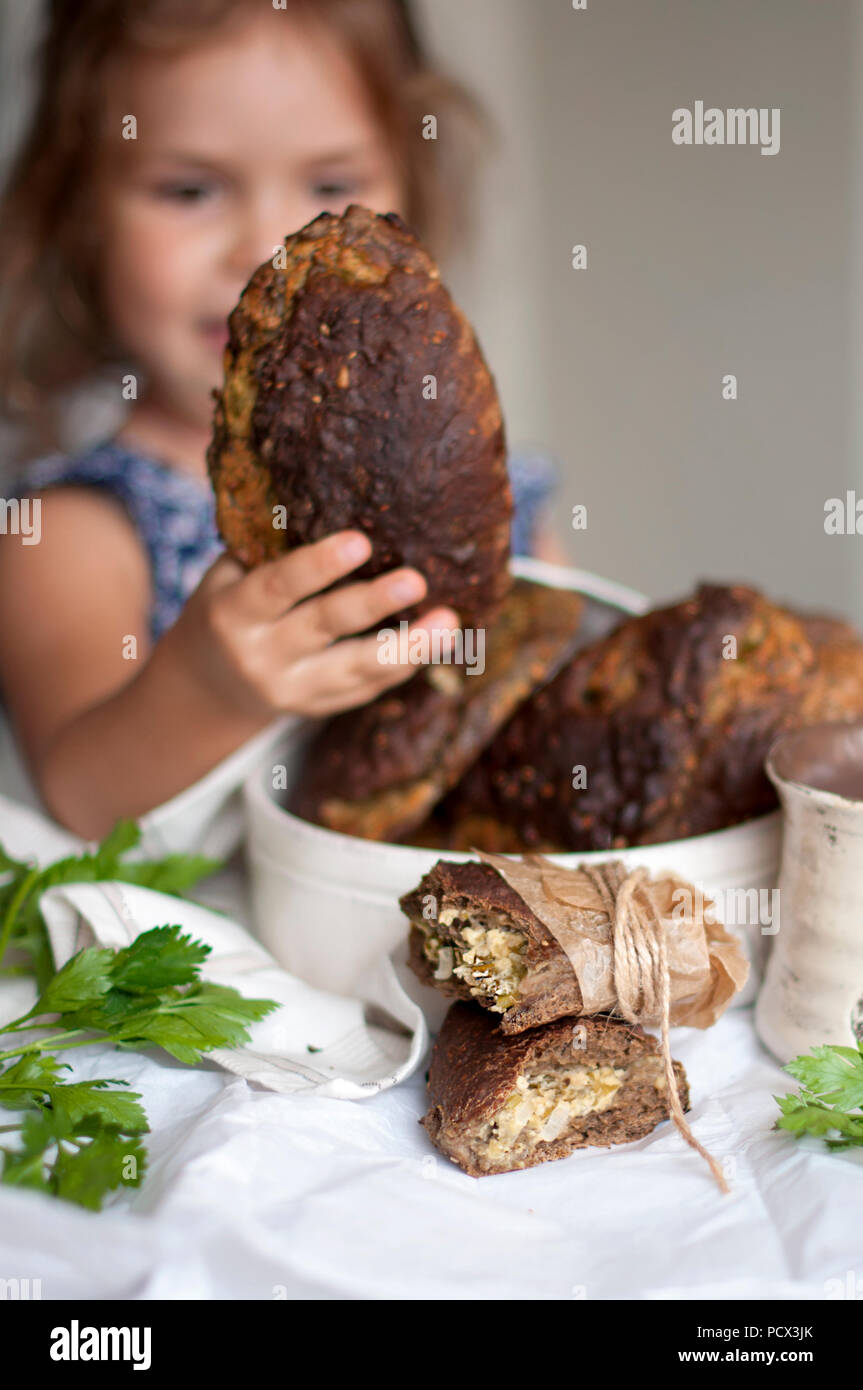 A little girl is eating pies in the living room. Delicious homemade ...