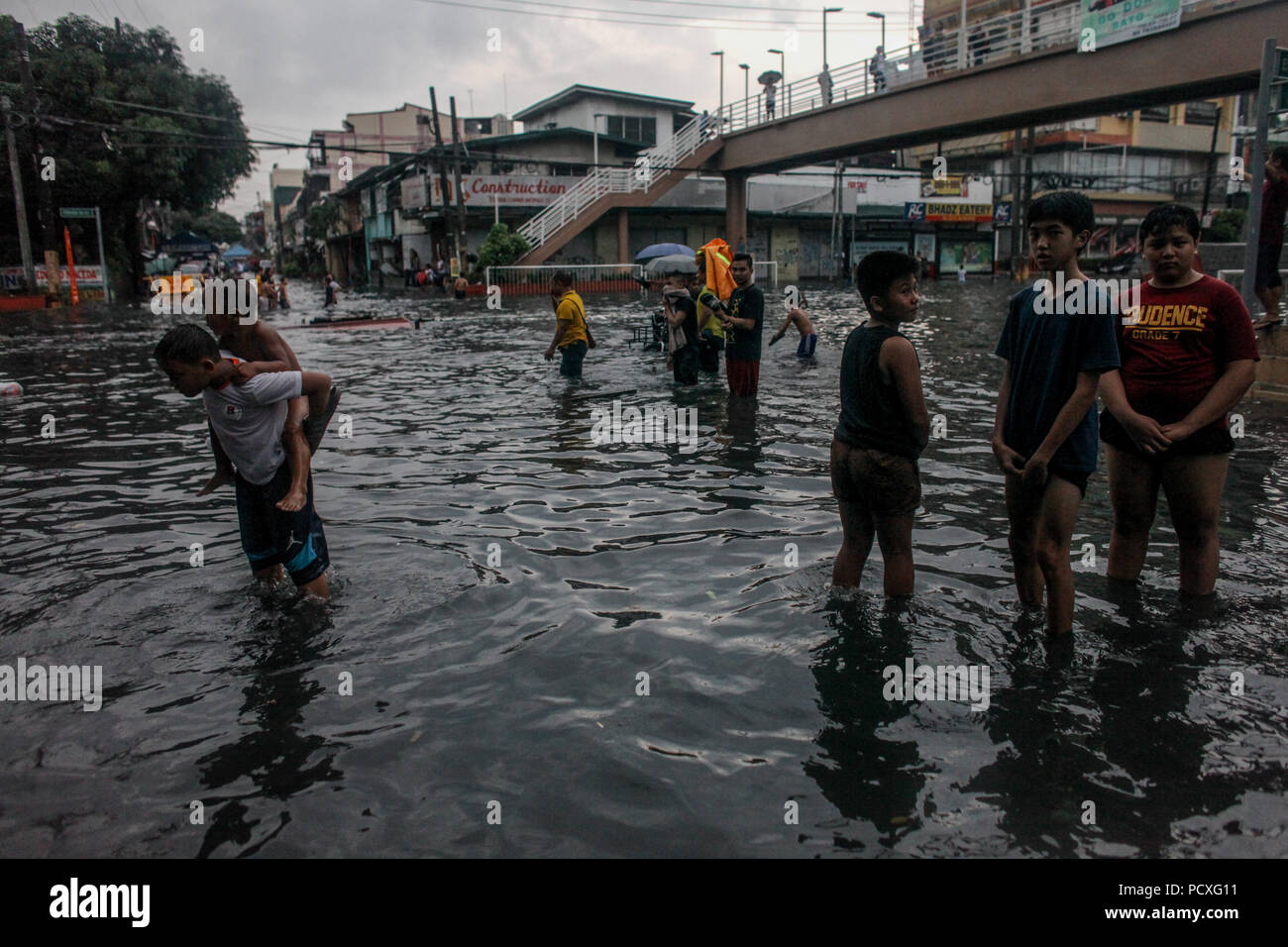 Manila, Philippines. 4th Aug, 2018. People wade through flooded streets ...