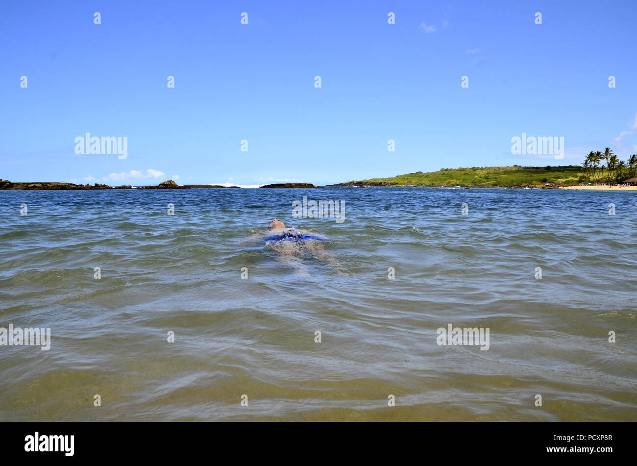 Young man floating face up at Poipu Beach Park in Koloa on the Island ...