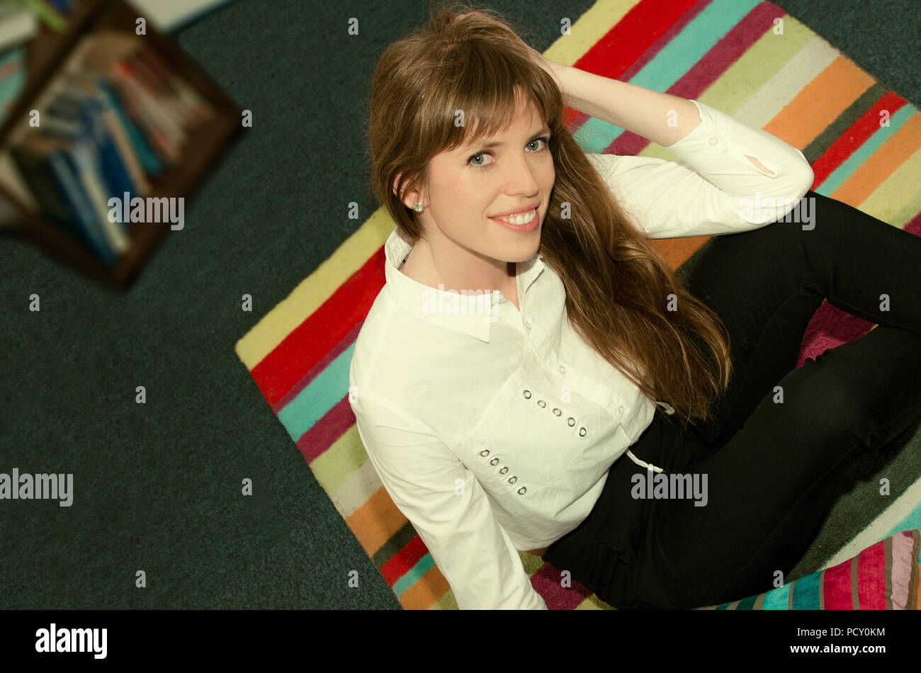 the girl relaxed on the colorful rug after studying psychology. Girl ...