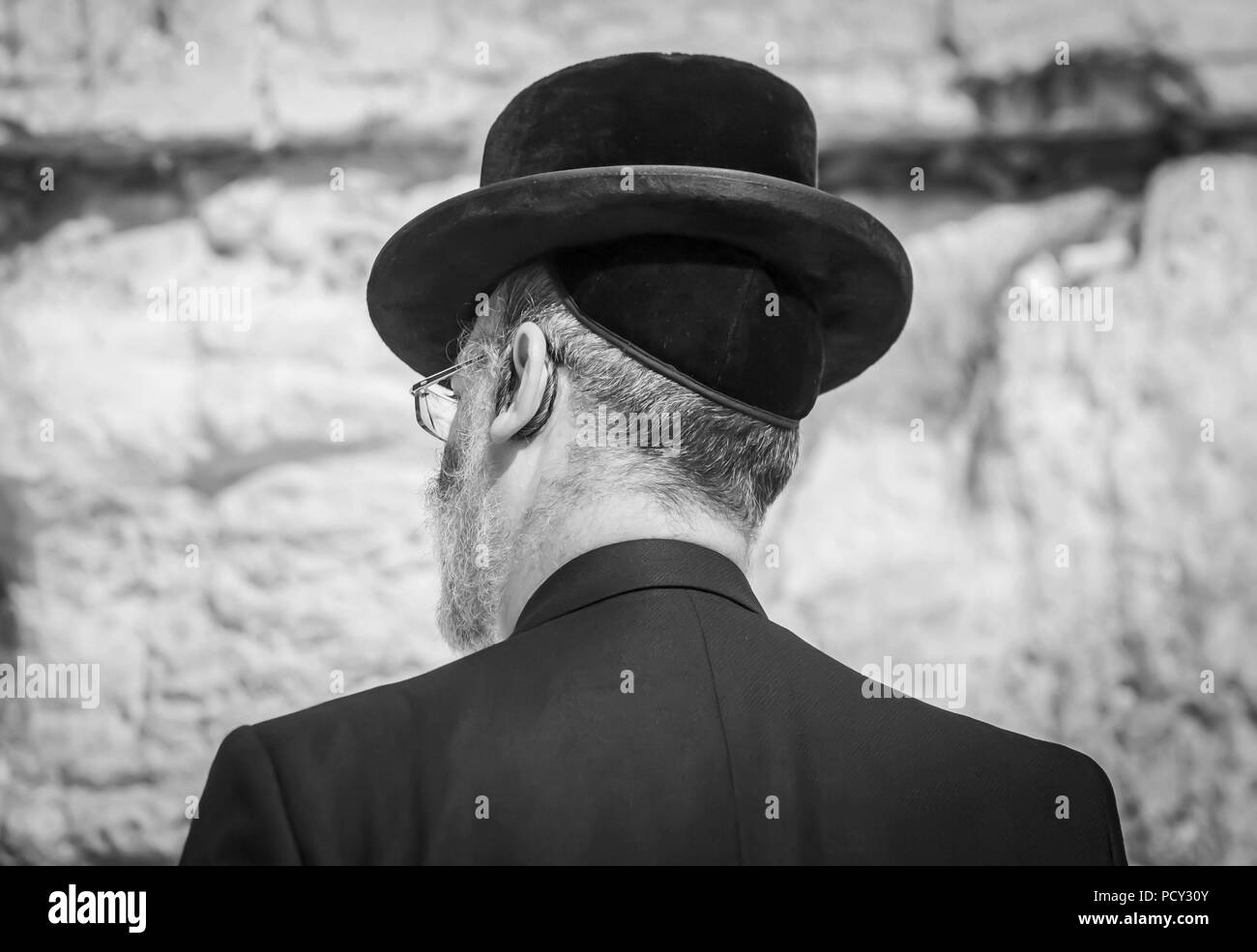 Jewish Orthodox man praying at the Wailing wall, Western wall black and ...