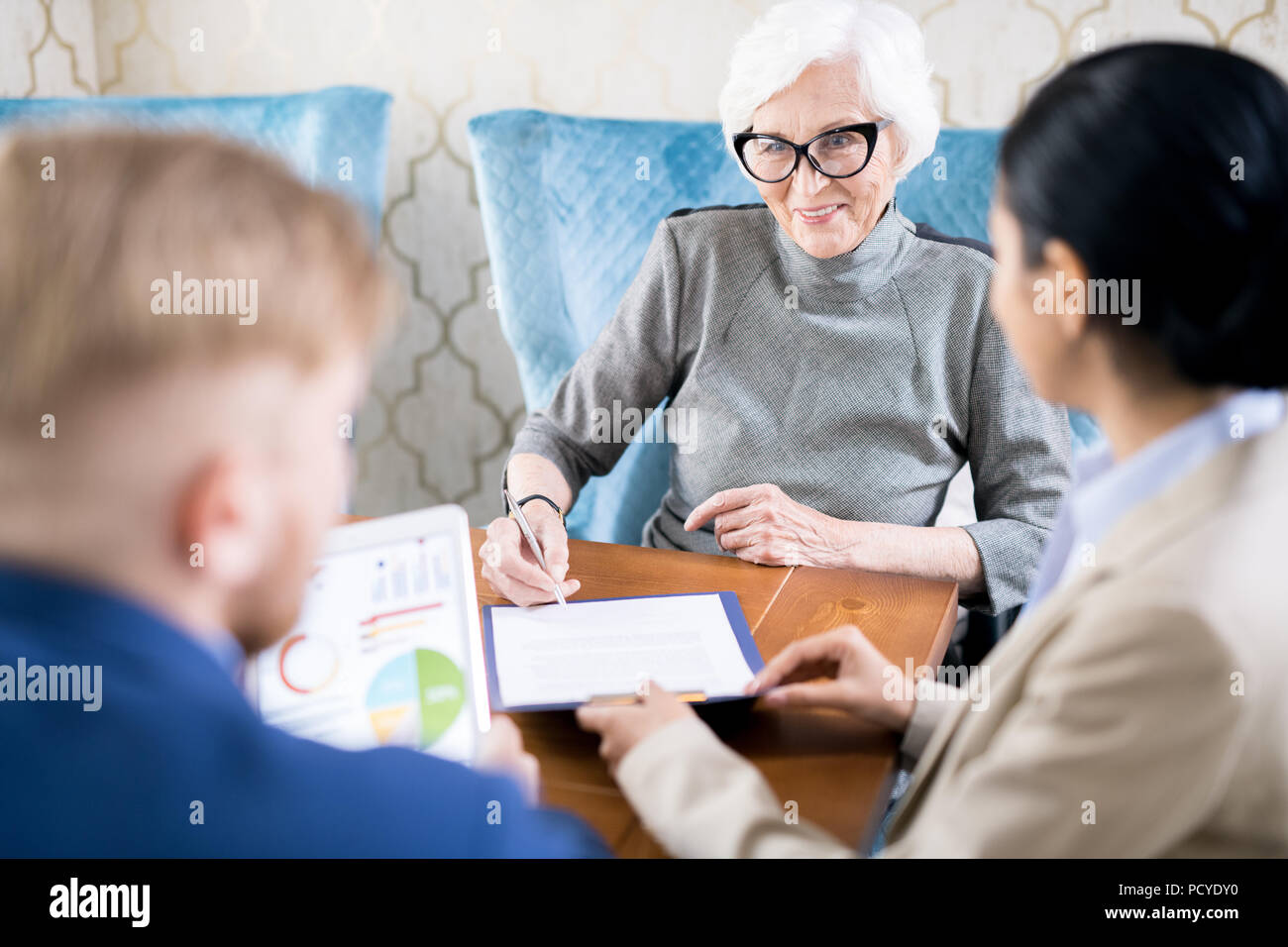 Senior woman signing a contract Stock Photo - Alamy