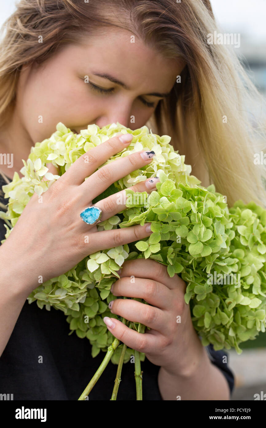 Young woman sniffing a bouquet of hydrangeas Stock Photo - Alamy