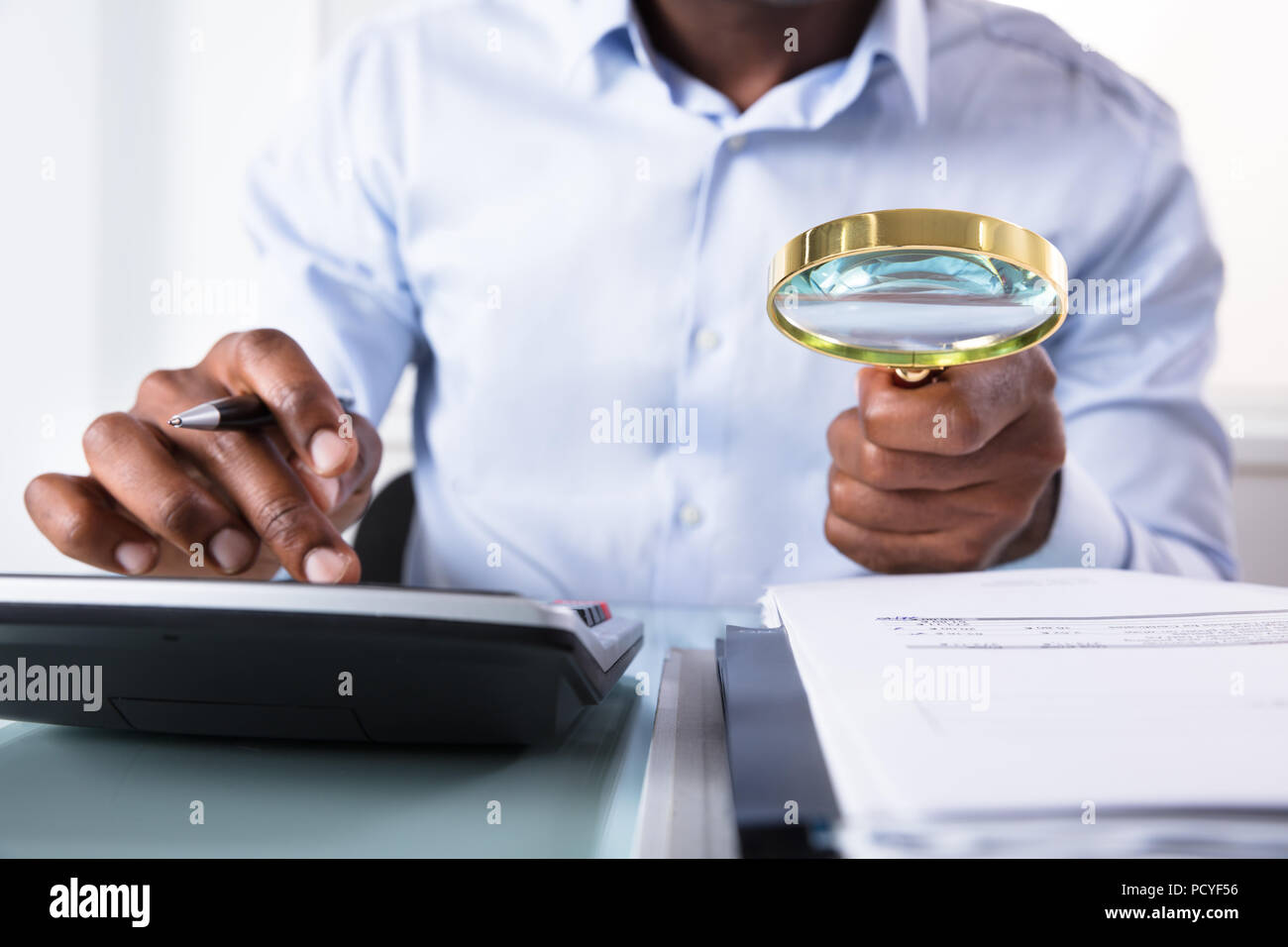 Businessman Holding Magnifying Glass Calculating Invoice Using ...
