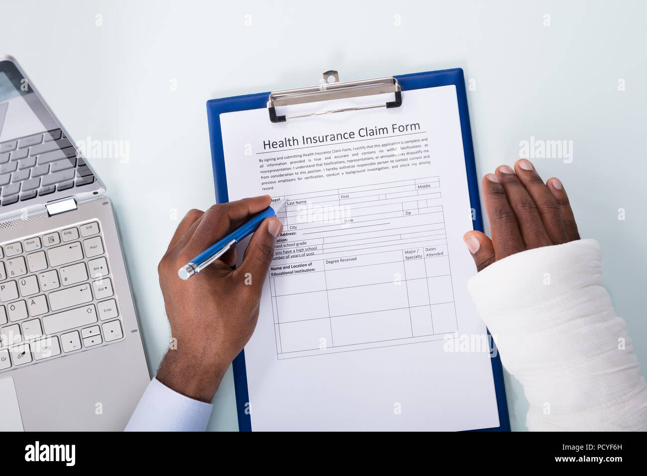 Overhead View Of Injured Man With Bandage Hand Filling Insurance Claim ...