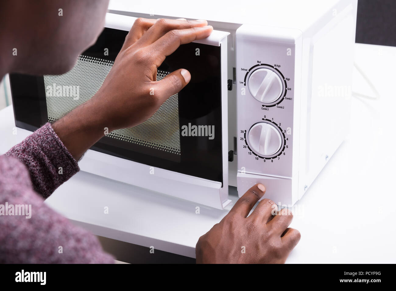 Close-up Of A Man Pressing Button Of Microwave Oven Stock Photo - Alamy